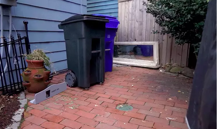 Нова автоматизирана кофа за боклук се придвижва до бордюра в Деня на боклука