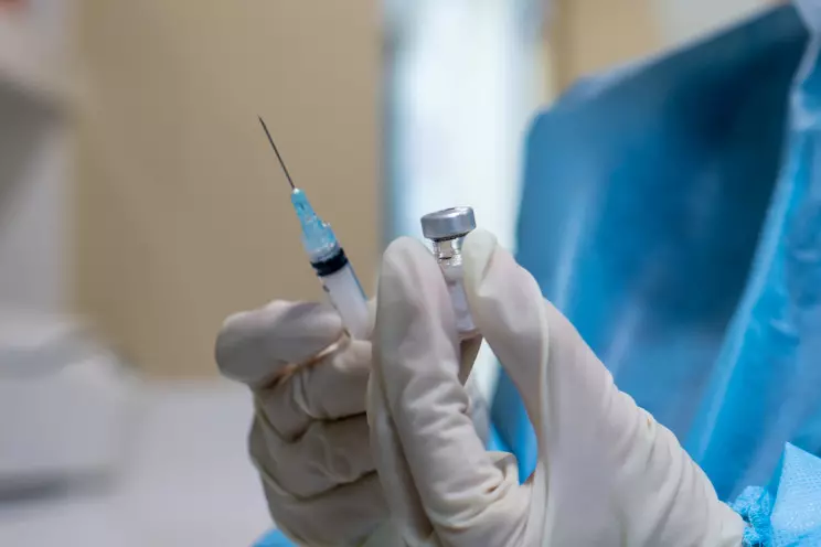 helsepersonell som forbereder seg på å trekke ut en dose vaksine