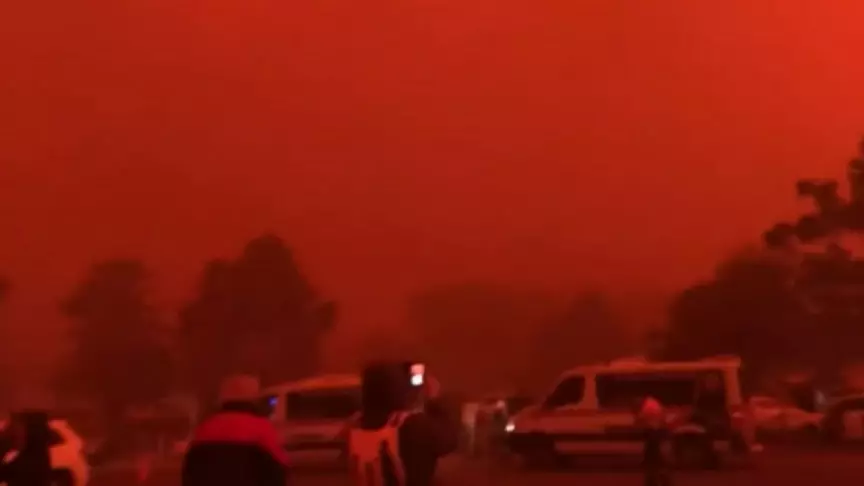 Os veciños de Australia corren cara á beira da auga desde o incendio forestal mentres o ceo se torna carmesí